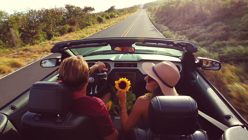 Happy Young Hipster Couple Driving Convertible On Country Road Into ...