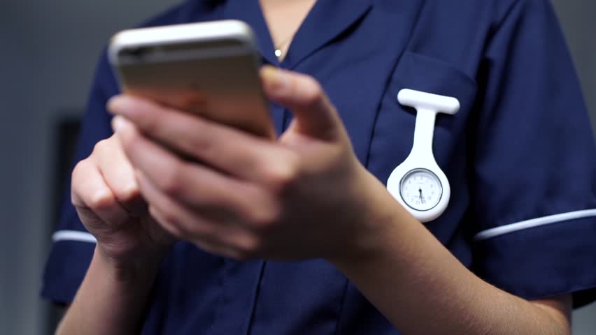 Close Up British NHS Nurse Hands And Uniform Using Mobile Cell Phone ...