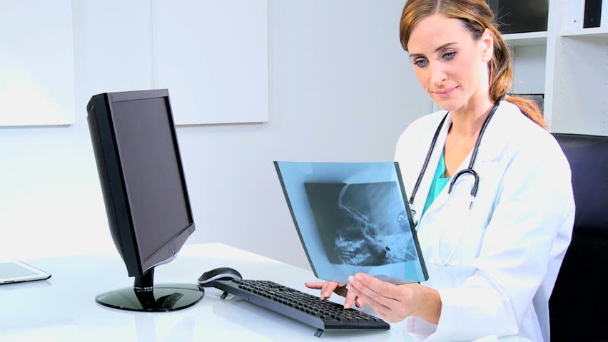 Female Caucasian Hospital Doctor Using Computer Monitor To Access Data ...
