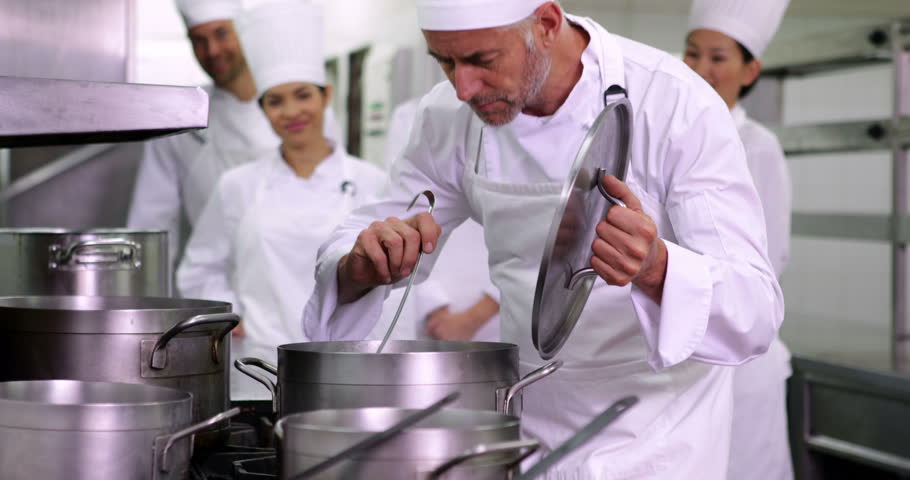 Head Chef Tasting Pot Of Soup Making Ok Sign In A Commercial Kitchen ...